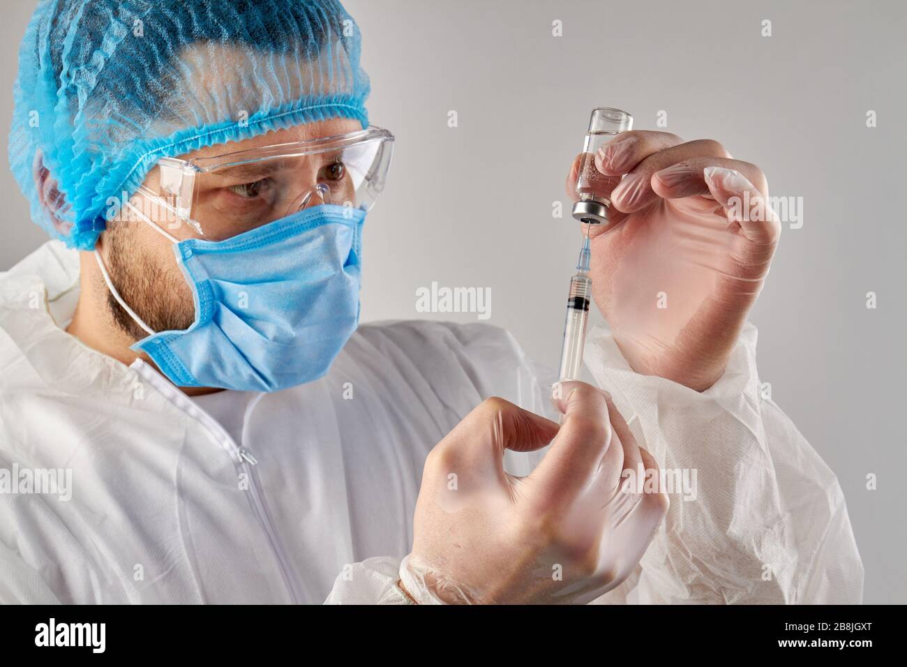 Medical scientist pulling syringe to fill it with medicine Stock Photo ...