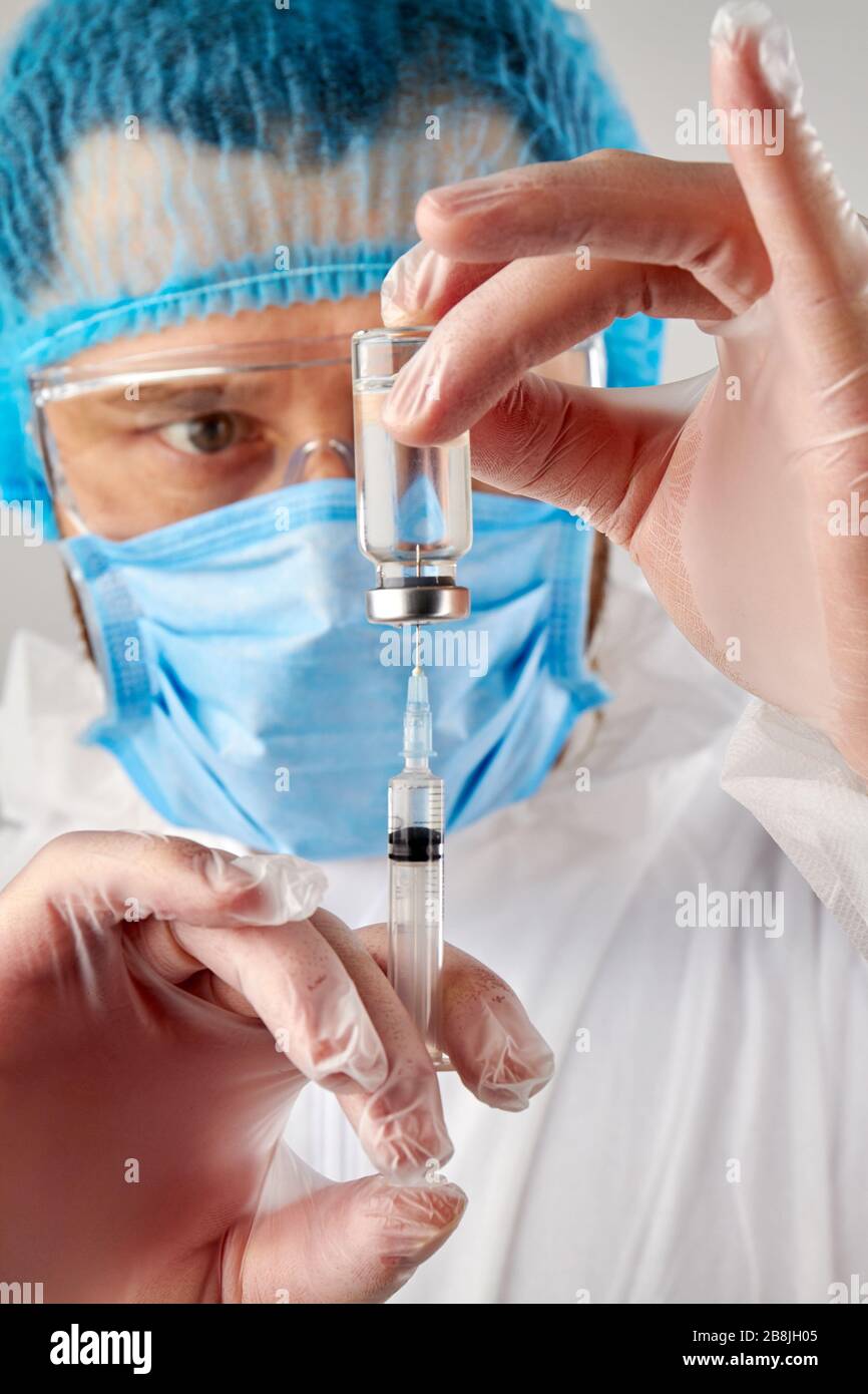 Doctor holding syringe with medicine vial Stock Photo - Alamy
