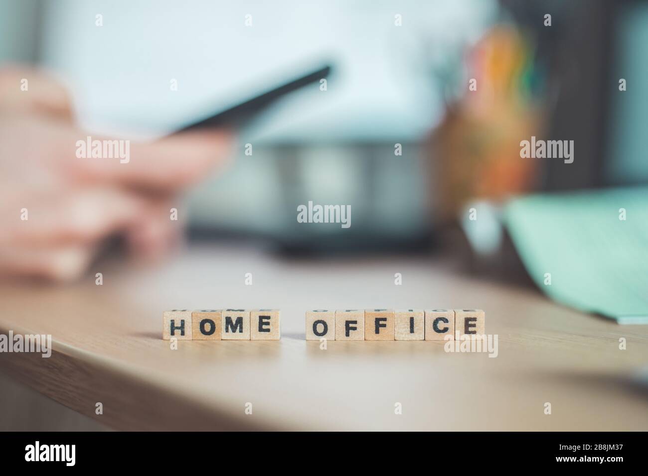 “Home Office” letters in foreground, man working in home office in ...