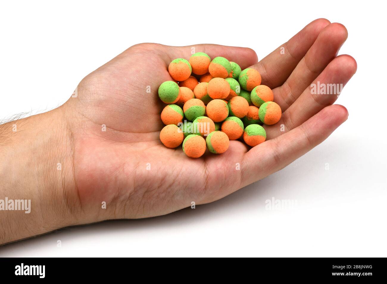 Hand holds boilies, fishing baits for carp isolated on white background ...