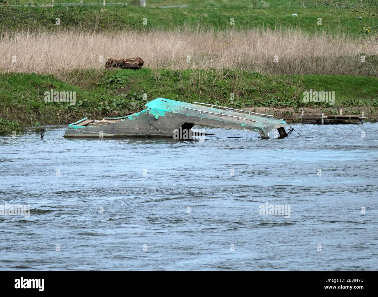 Small sunken boat in a river Stock Photo - Alamy