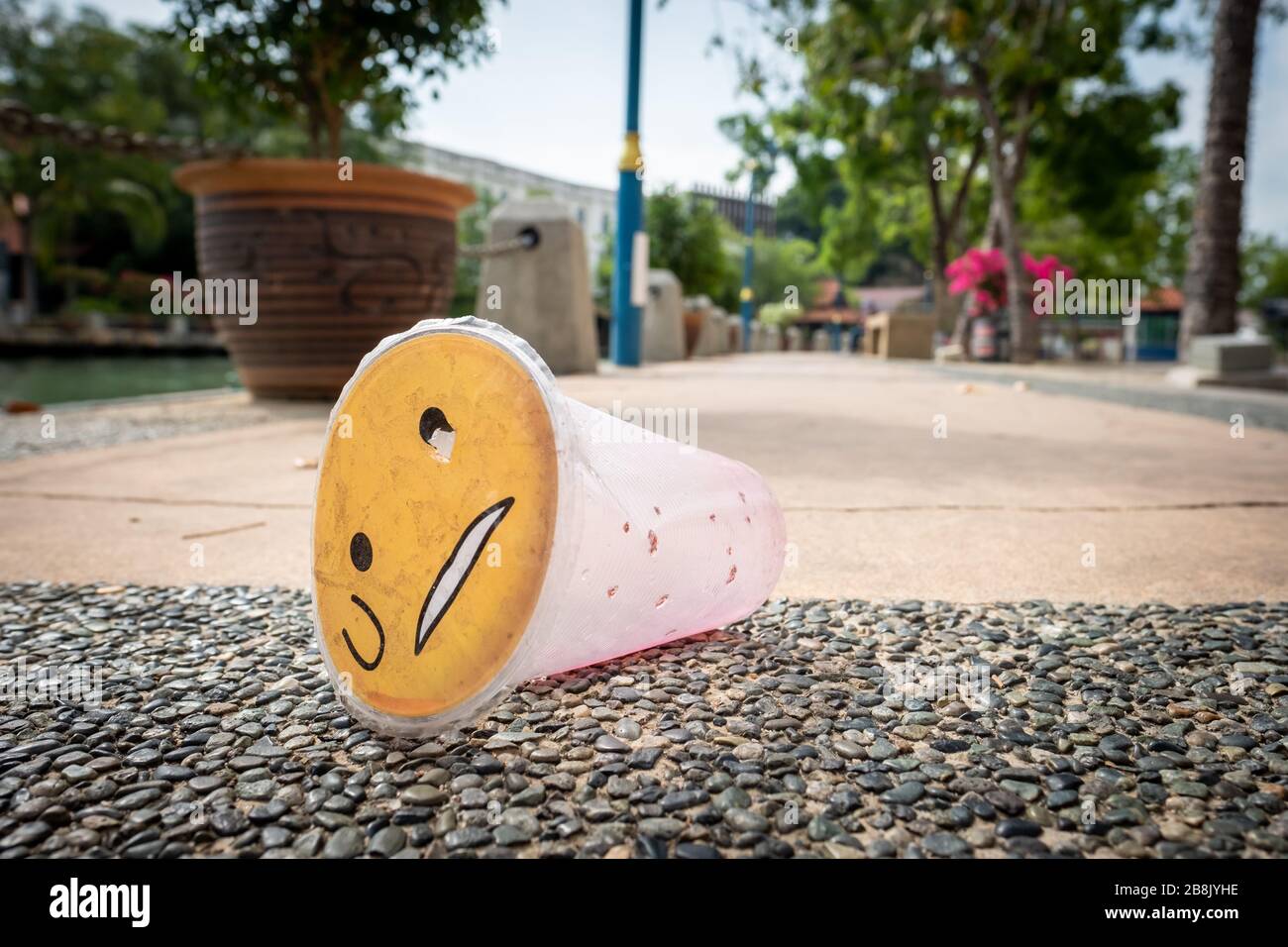 Plastic waste pollution- A disposed plastic drinking contain with a sad ...