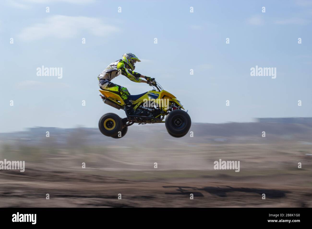 A man on a four wheeler atv flying through the air Stock Photo - Alamy