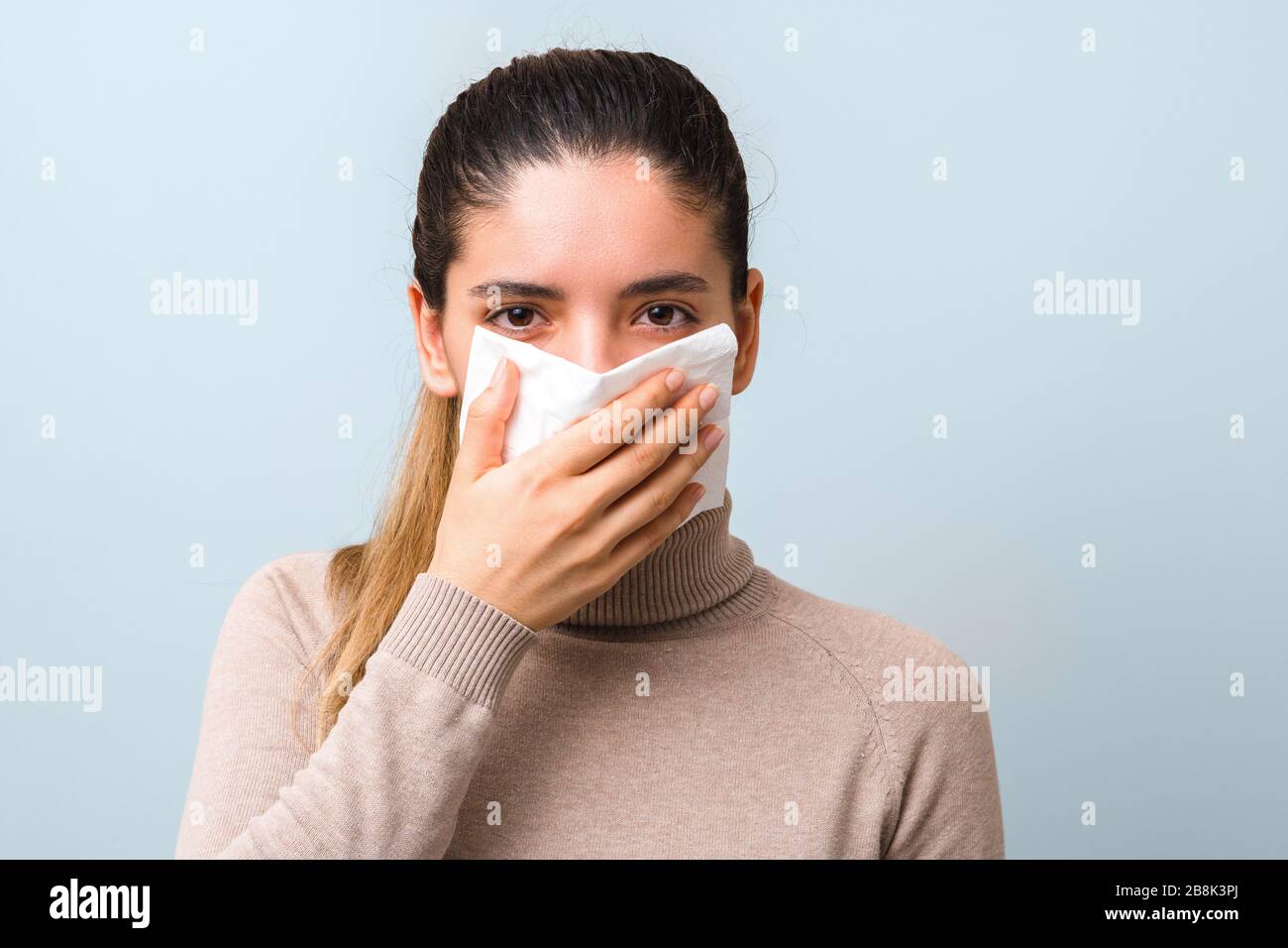 coronavirus symptoms. desperate woman with fever and headache holding a ...