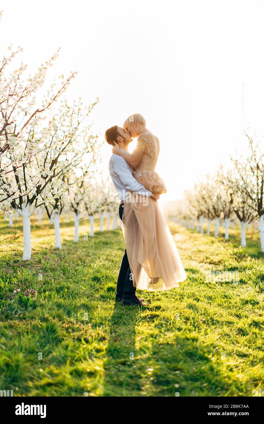 Beautiful young sensual couple kissing in romantic place, spring blooming apple garden. Happy ...