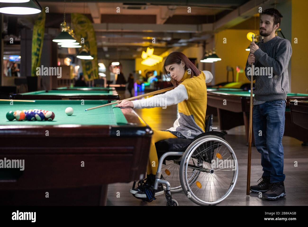 Beautiful disabled girl in a wheelchair playing billiards with her ...