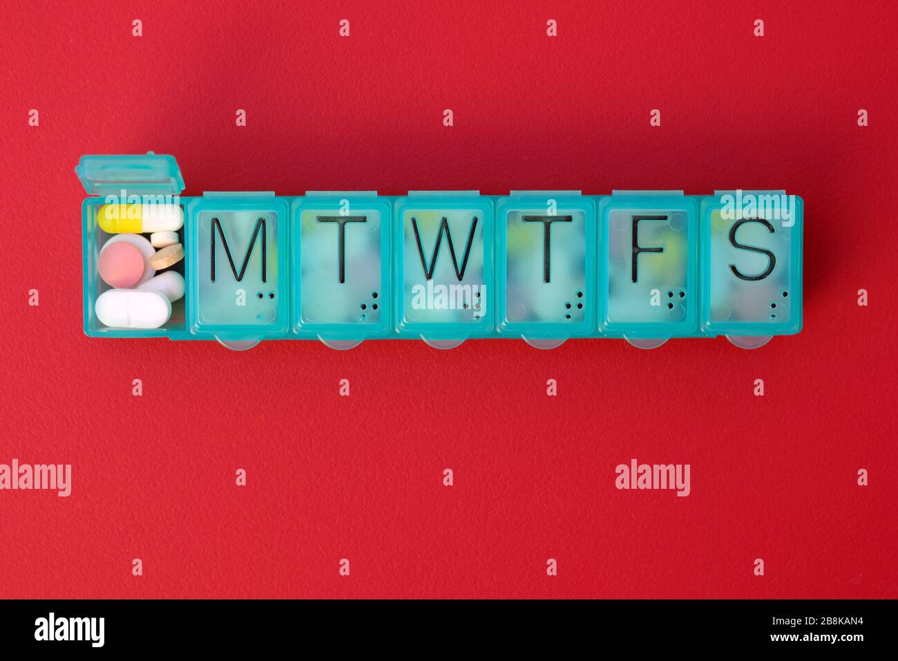 Green plastic pill box for seven days. Pill container top view ...