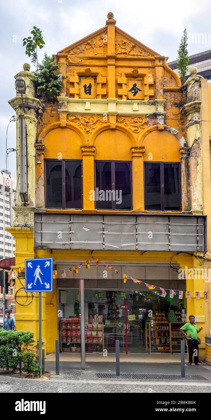 Man standing front of traditional shophouse with Chinese letters on ...