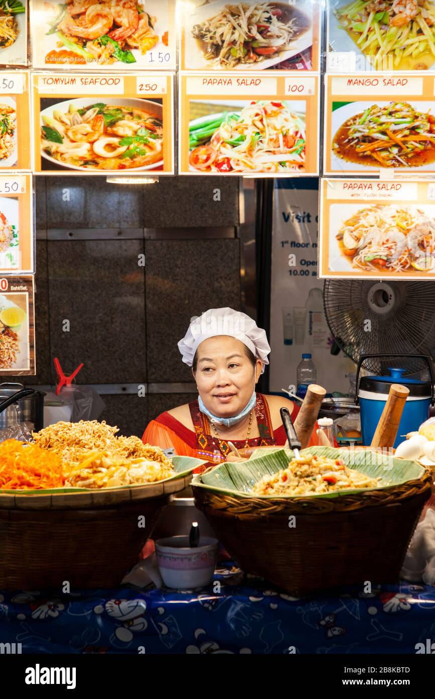 Local female chef cooking and selling street food from her stall, with ...