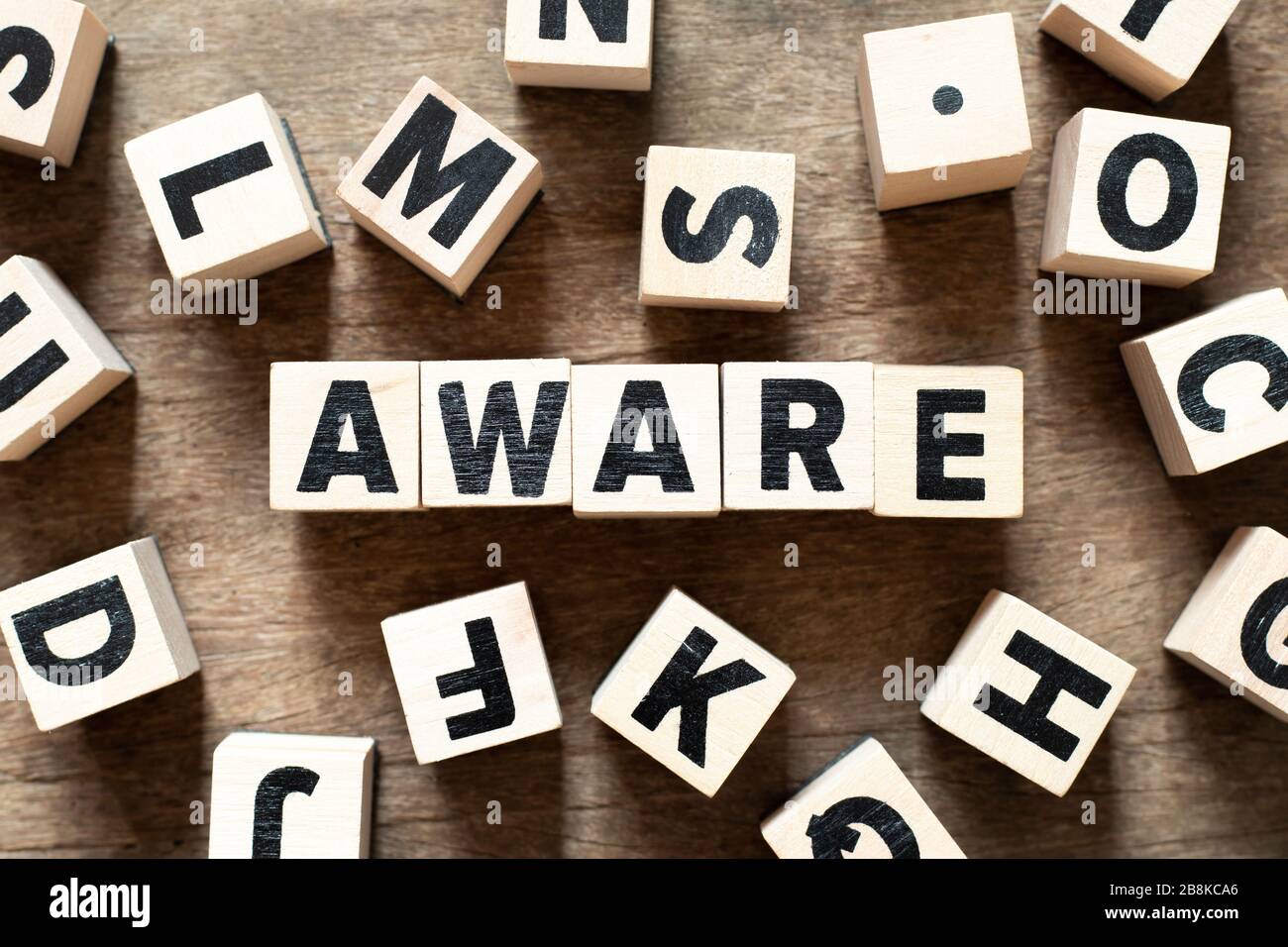 Wood letter block in word aware on wood background with another ...