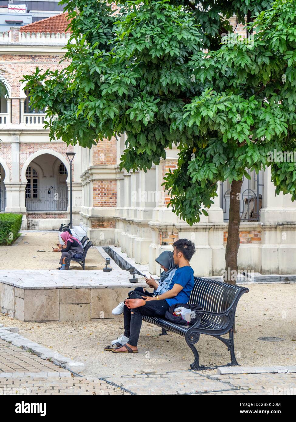 Couple sitting on metal bench along River of Life walkway at Sultan ...