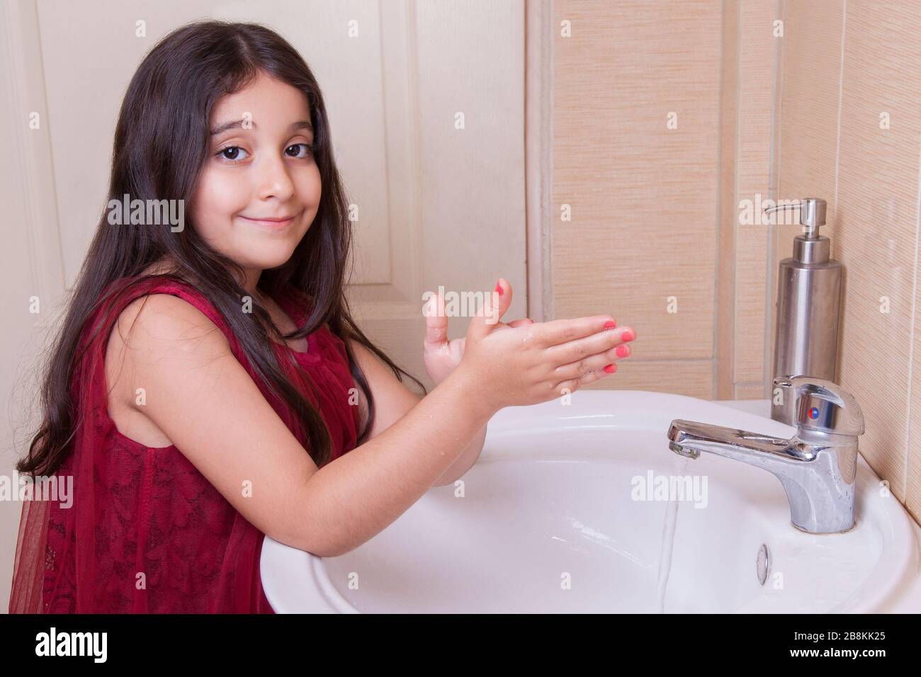 washing hands. Beautiful happy girl washing her hands with soap foam ...