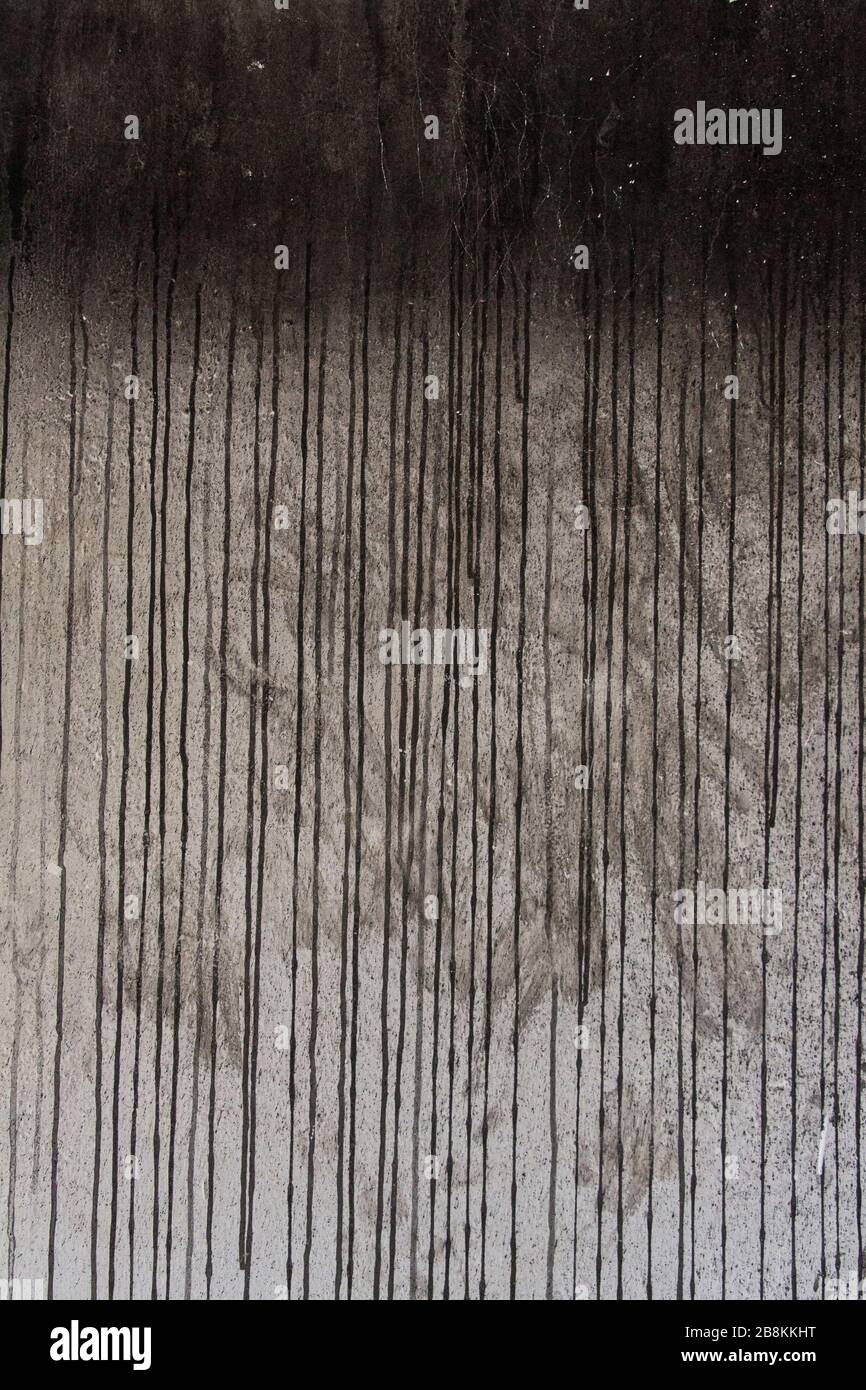 painted black dripping on gray wall, dripping liquid, paint flows ...