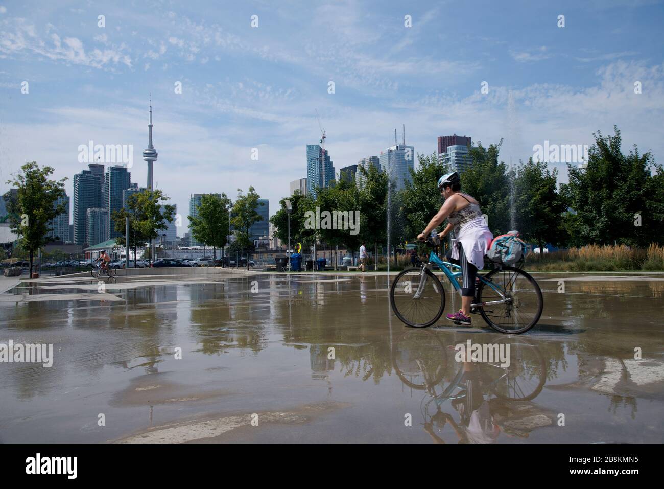 riding a bicycle in the park with Toronto cityscape as a background ...