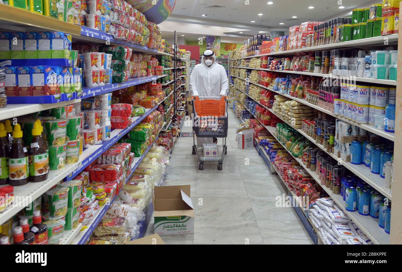 Hawalli Governorate, Kuwait. 22nd Mar 2020. A man buys goods at a ...