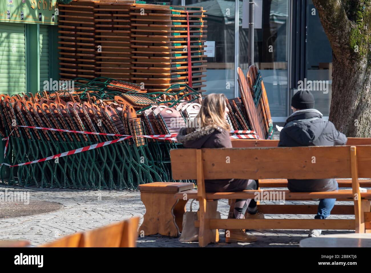 Munich, Germany. 22nd Mar, 2020. Walkers sit on an empty bench in the ...