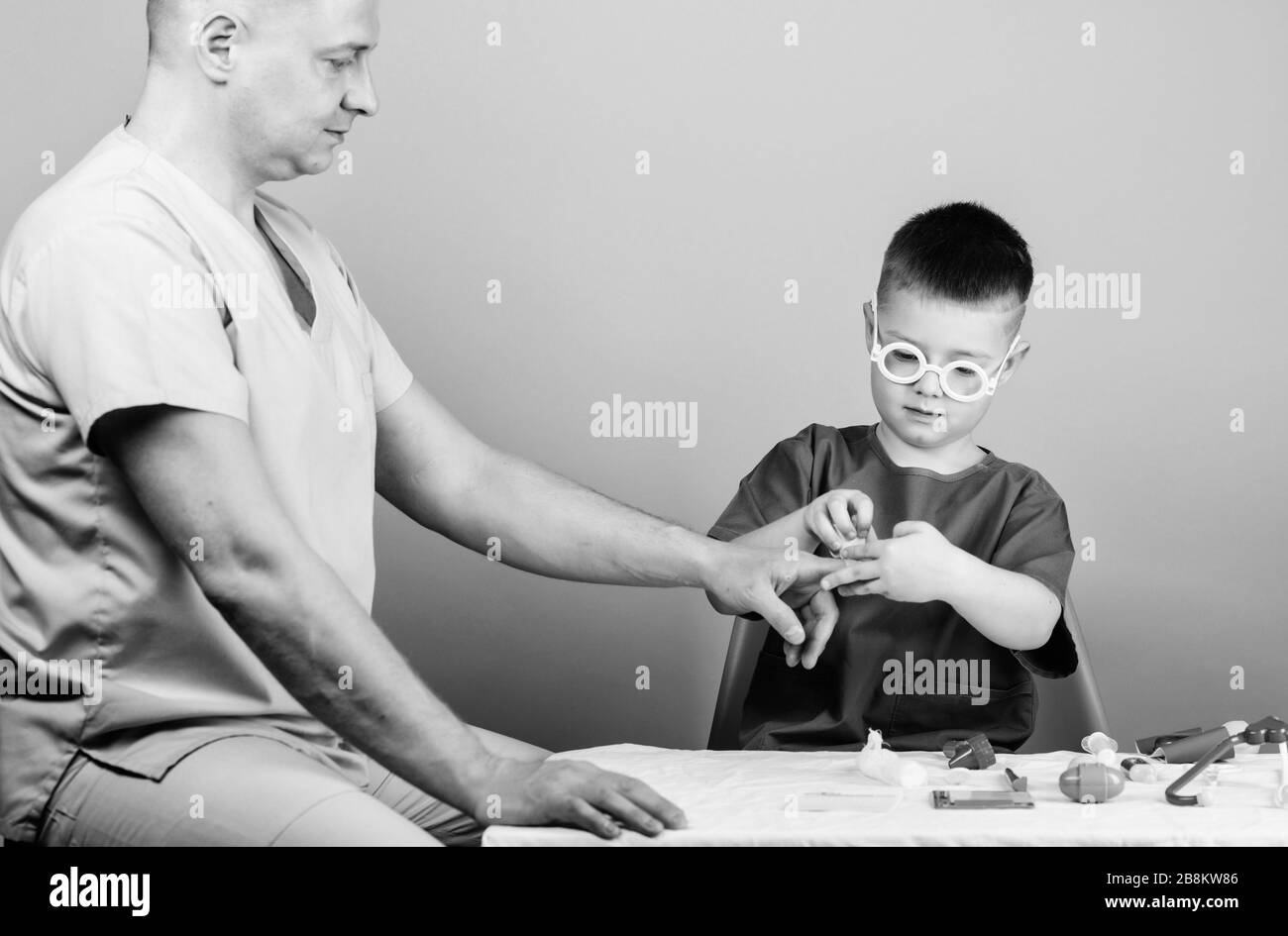 small boy with dad in hospital. father and son in medical uniform ...