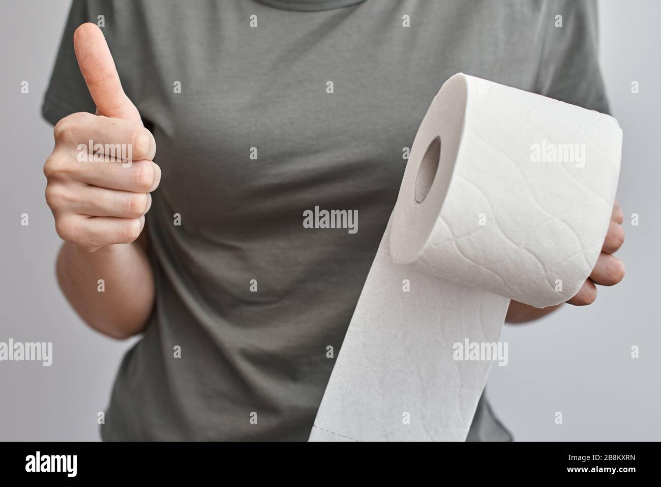 Woman hand hold toilet paper roll and show thumb up gesture, close up ...