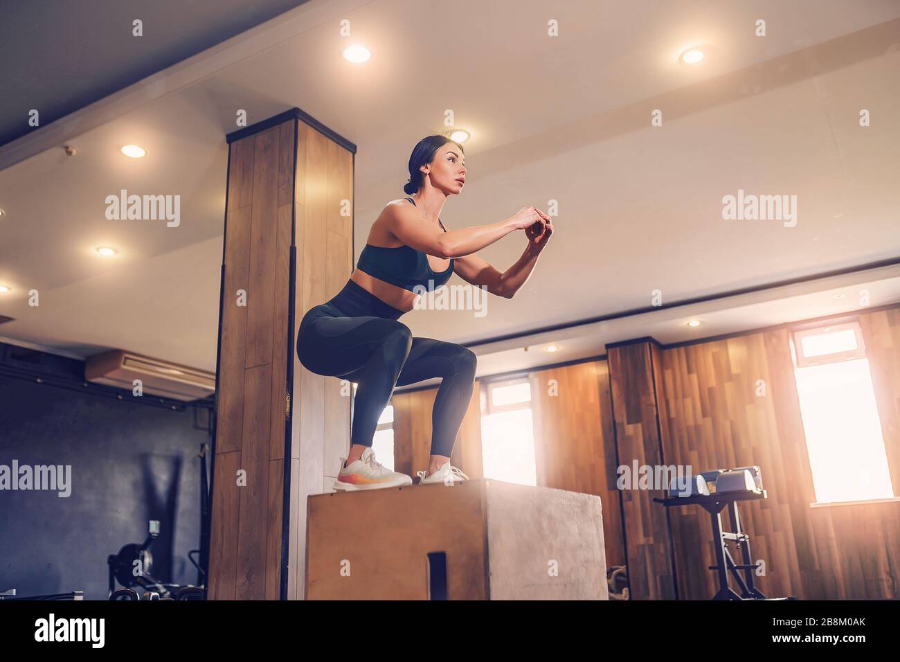 Shot of young woman working out with a box at the gym. Female athlete ...