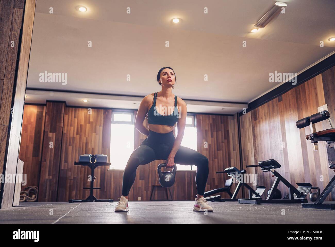 Young adult fitness woman doing swing exercise with a kettlebell as a ...