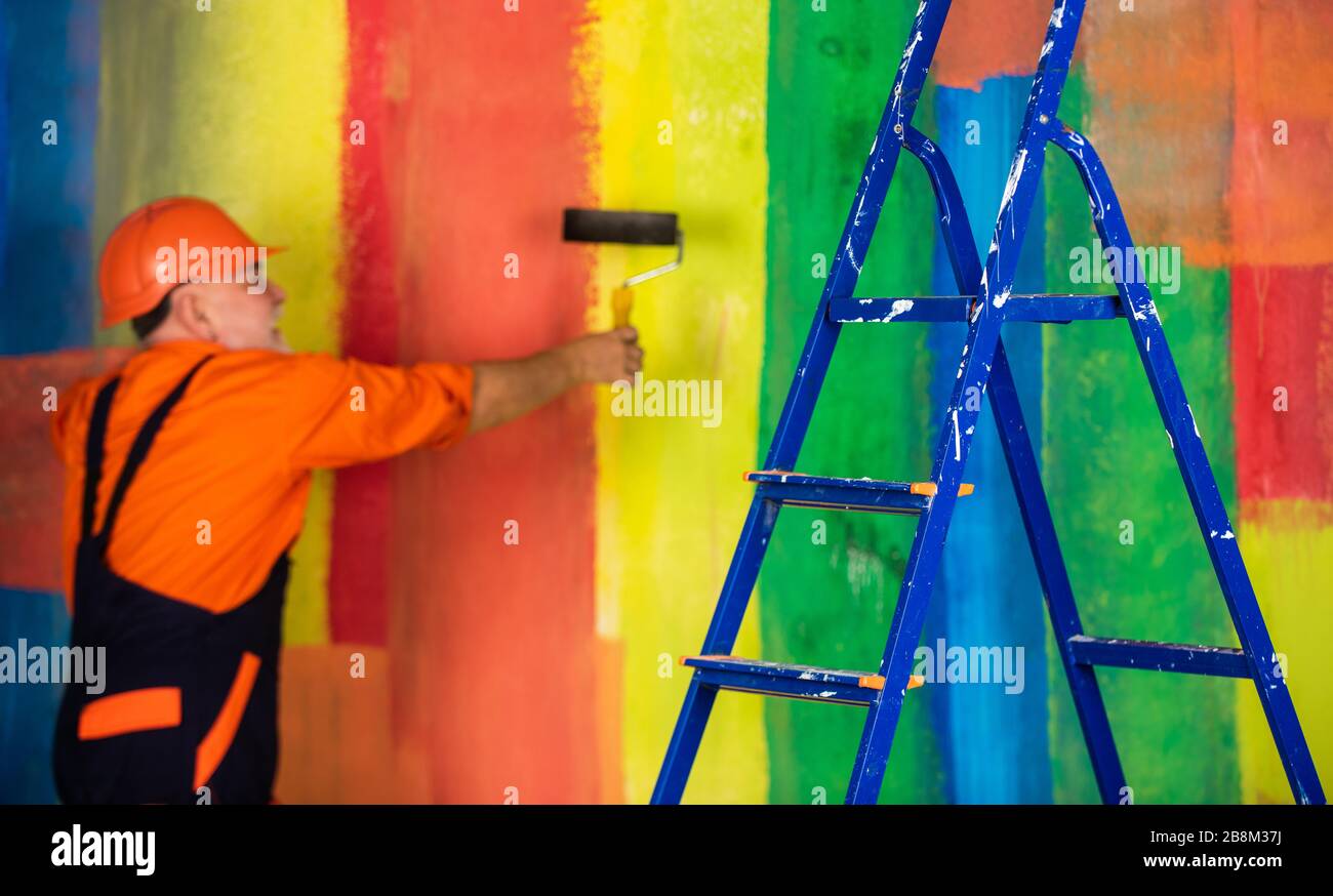 Painter man staircase. To make repairs. man in working clothes painting ...