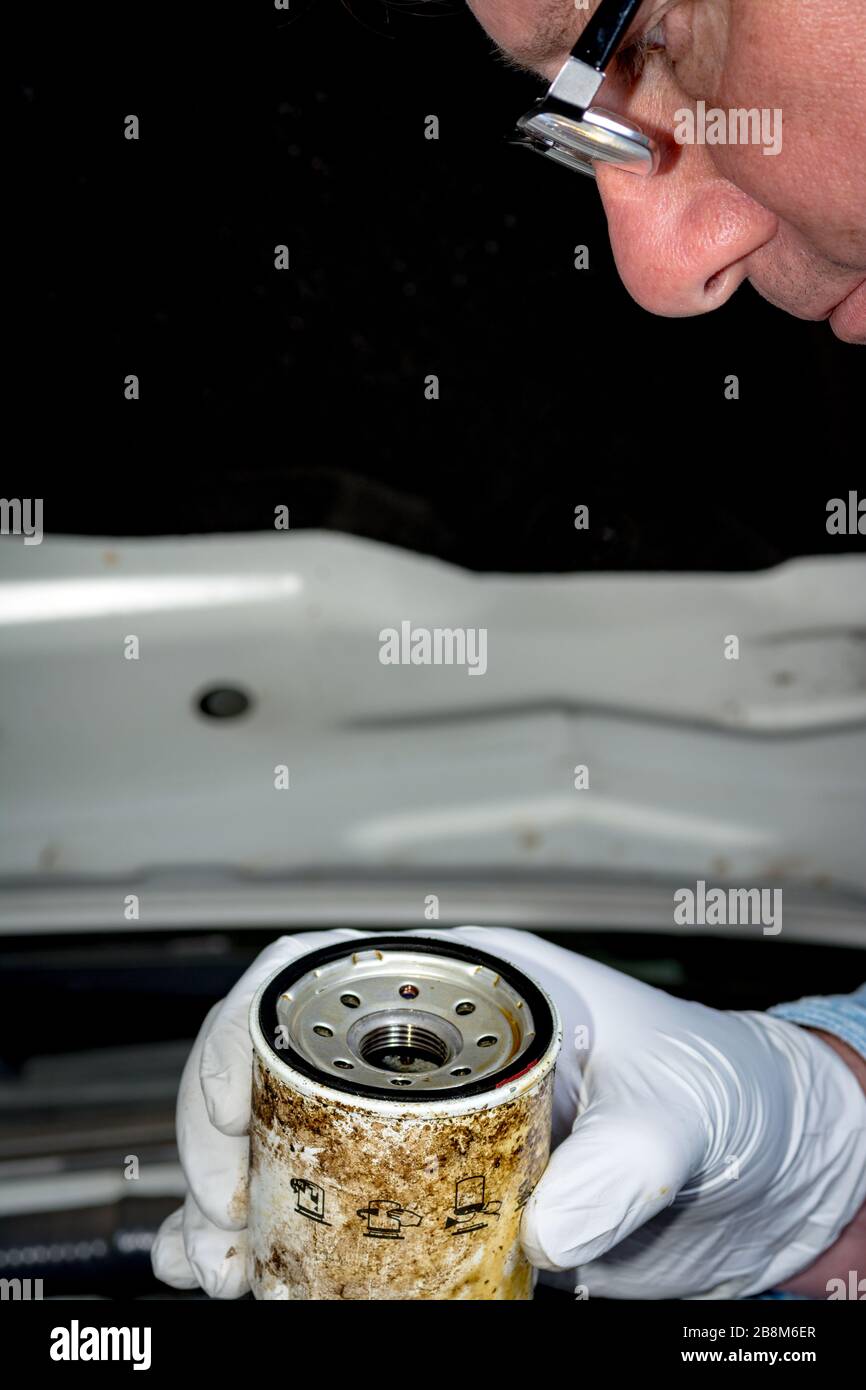 Inspection of a used oil filter done my auto mechanic Stock Photo - Alamy