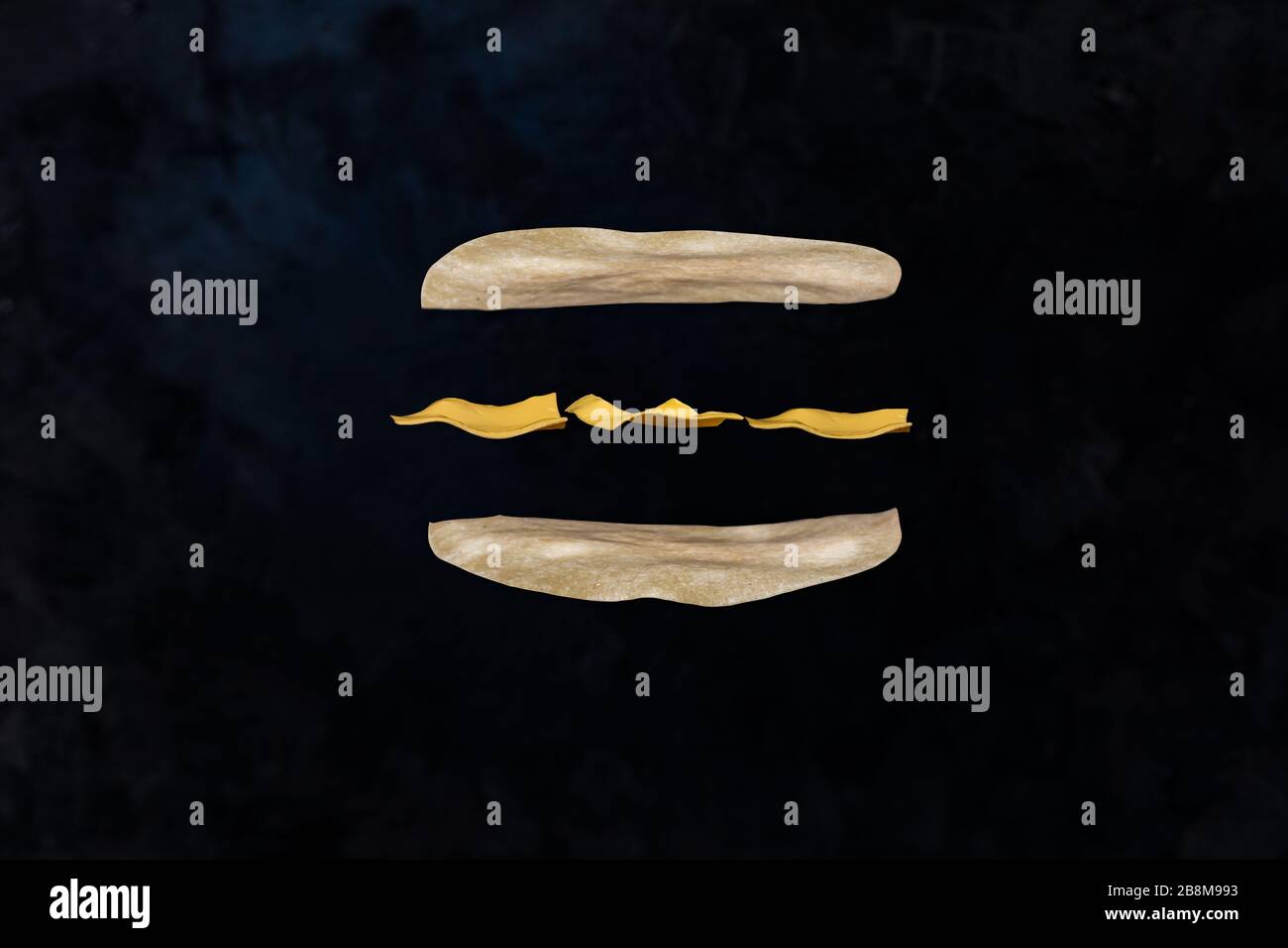 Layers of cheeseburger on black background Stock Photo - Alamy