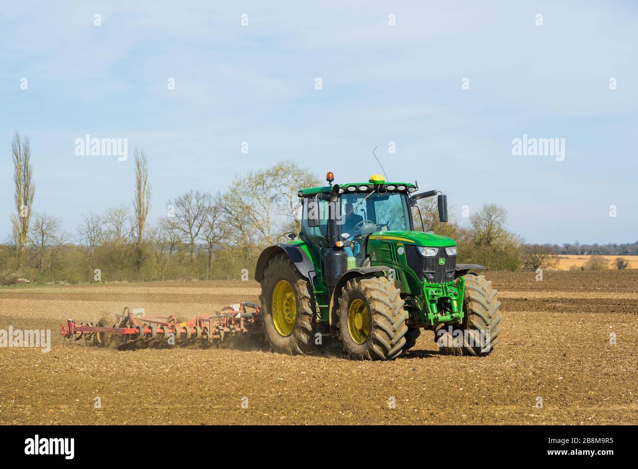 Tractor preparing soil for spring sowing. Much Hadham, Hertfordshire UK ...