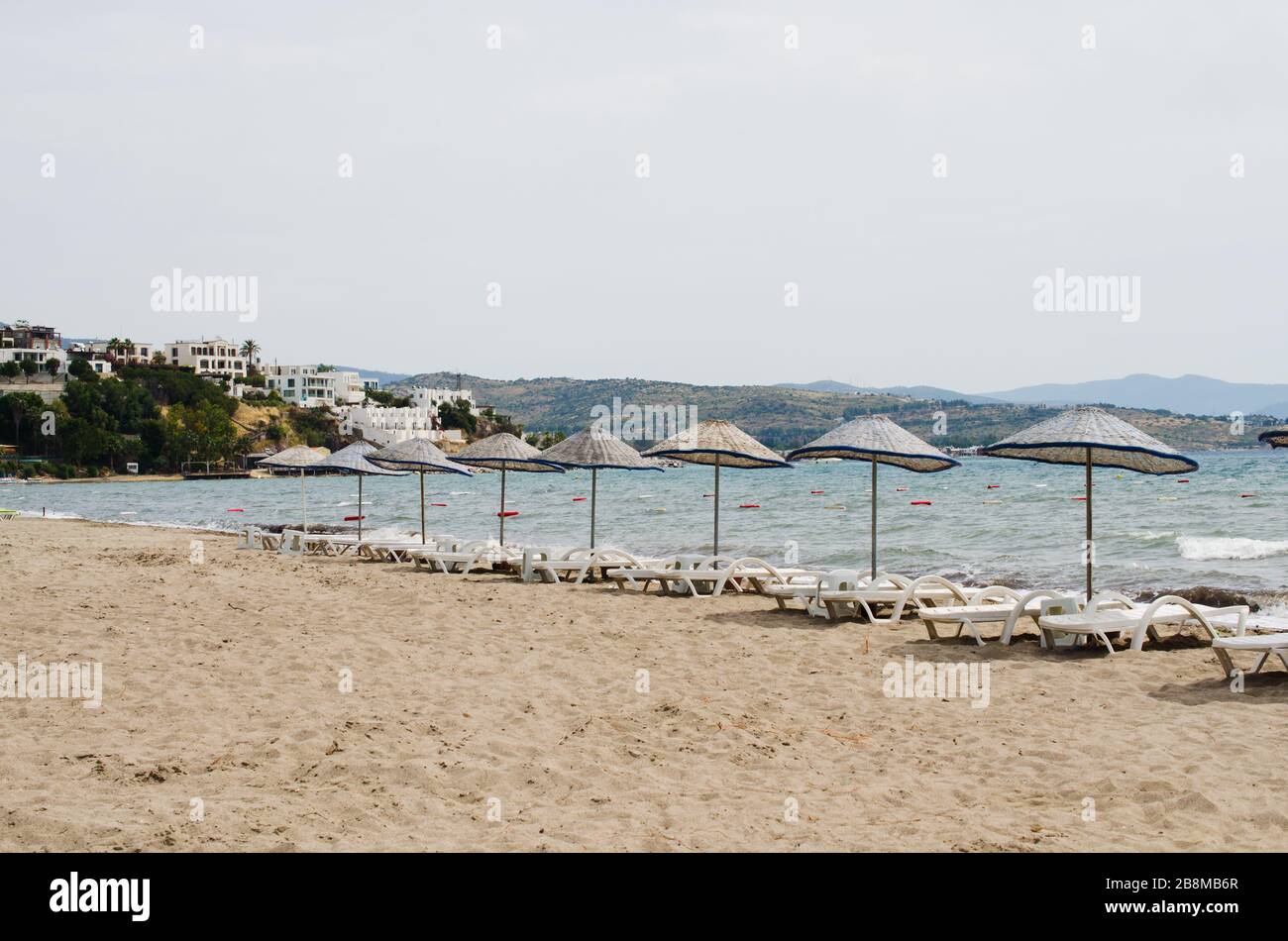 Rows of empty sun loungers and umbrellas on the beach. Camel Beach in ...