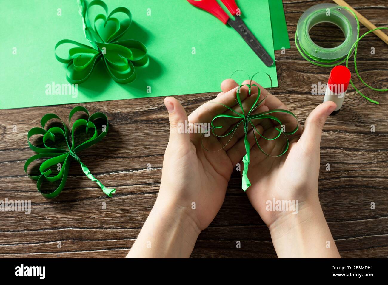 Child holds St. Patrick's Day clover, craft from paper. Handmade ...