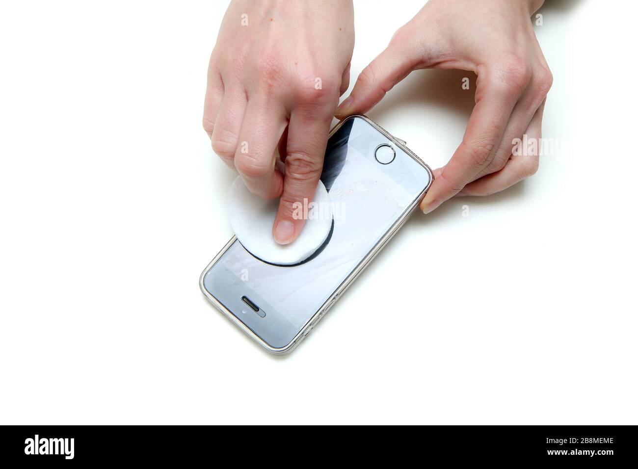 The detail of hands cleaning the mobile phone´s display with a tampon ...