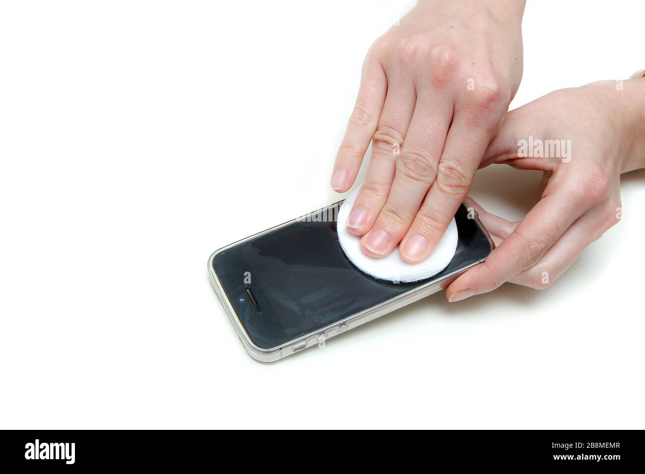 The detail of hands cleaning the mobile phone´s display with a tampon ...