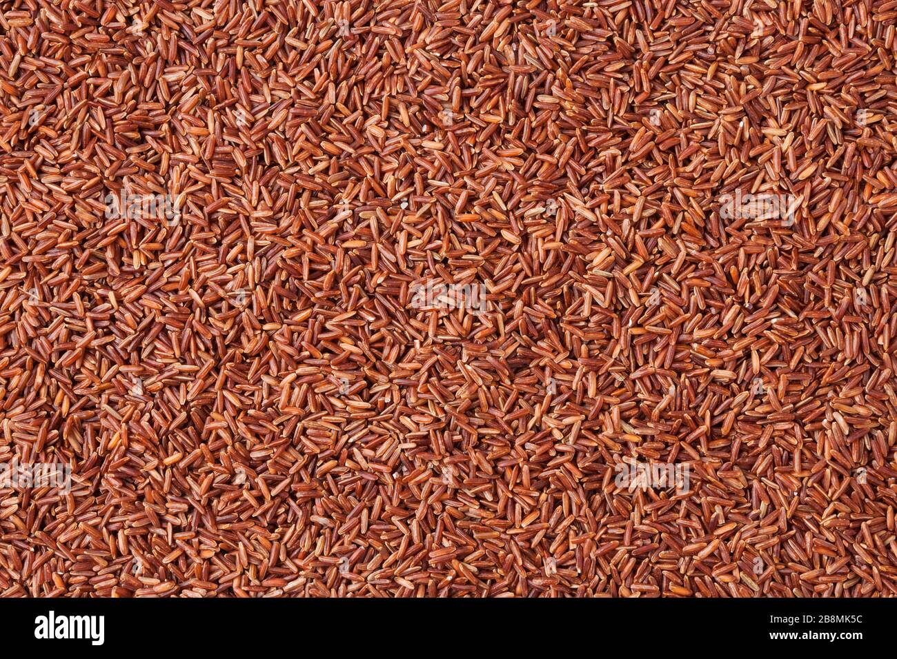 Uncooked red rice background Stock Photo - Alamy