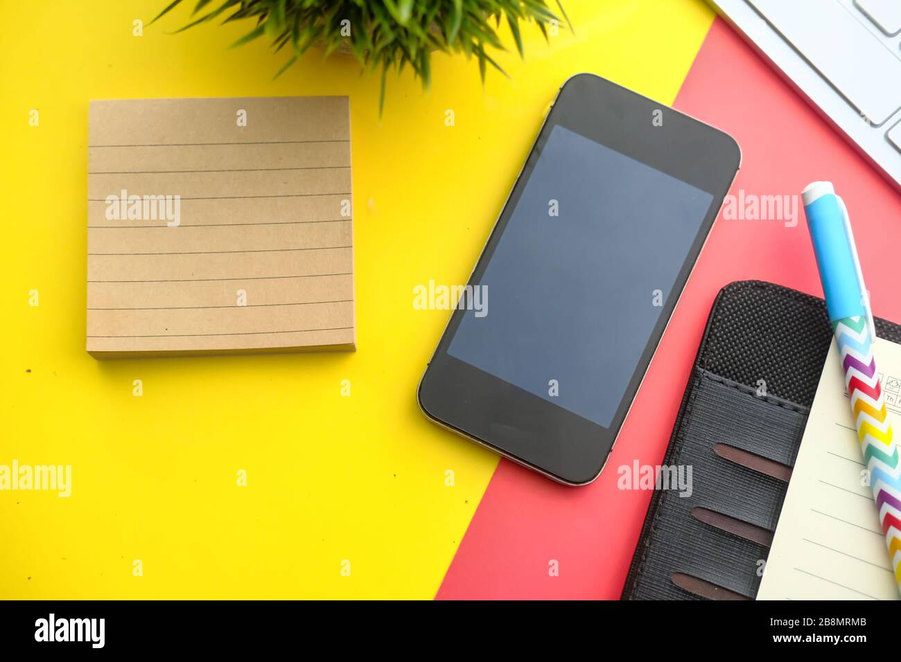 Blank screen cellphone on diagonal pastel yellow and red background ...
