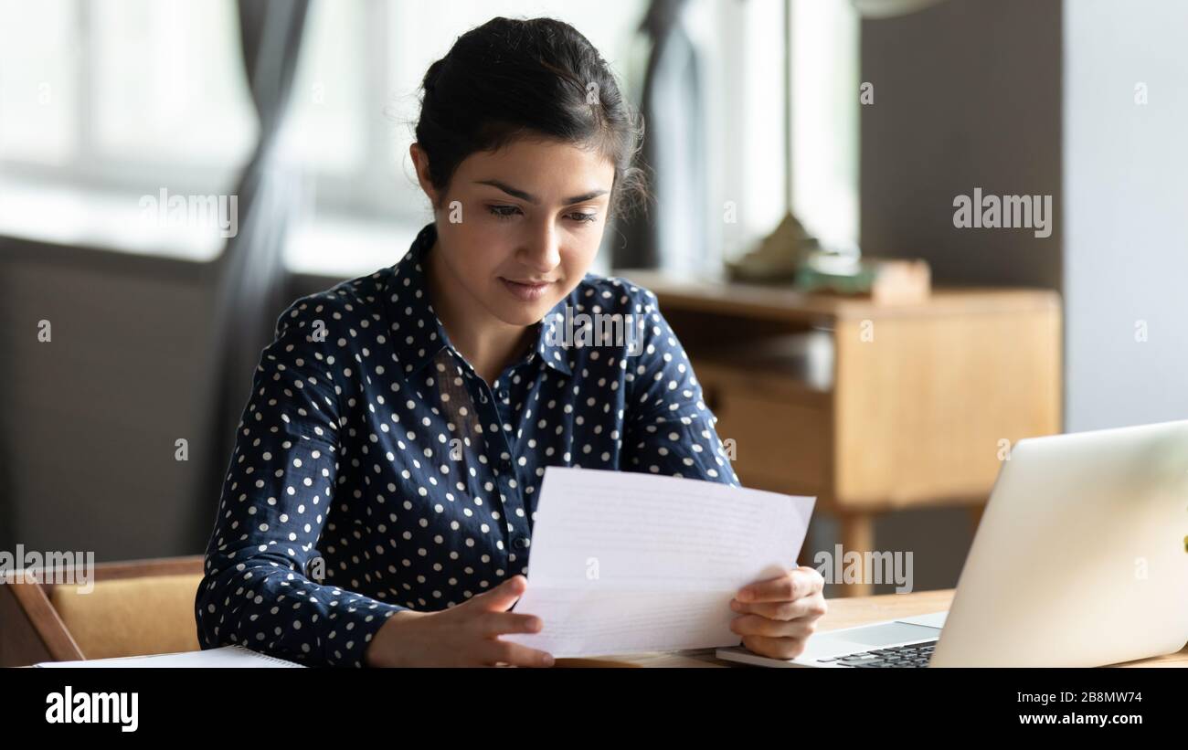 Focused Indian woman reading letter with important information Stock ...
