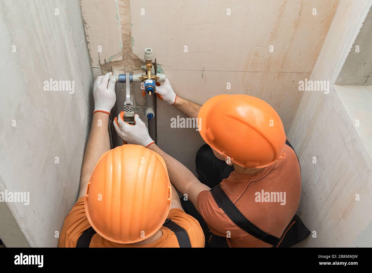 Workers are soldering a wall faucet for a built-in shower Stock Photo ...