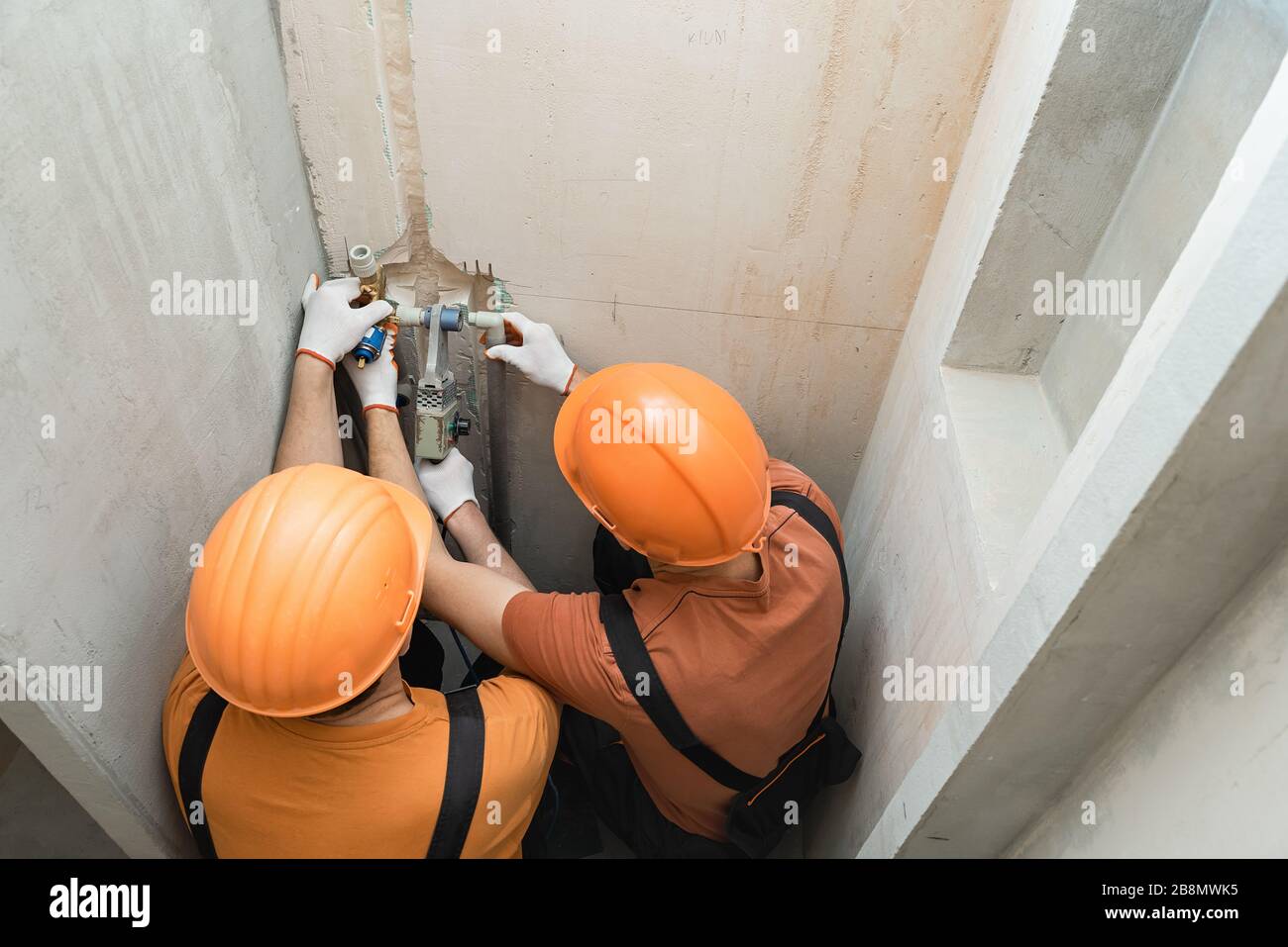 Workers are soldering a wall faucet for a built-in shower Stock Photo ...