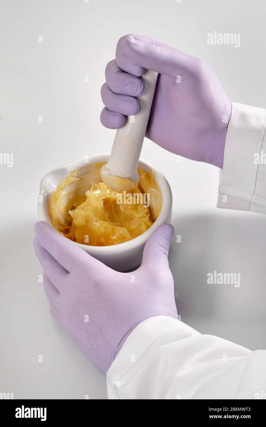 Closeup of the hands of a pharmacist or scientist, holding a mortar and ...