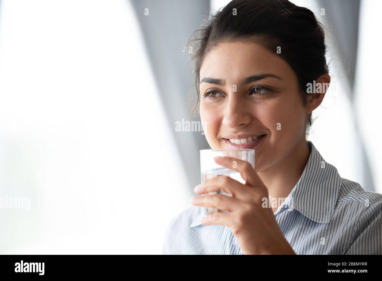 Head shot smiling Indian woman holding glass of pure water Stock Photo - Alamy