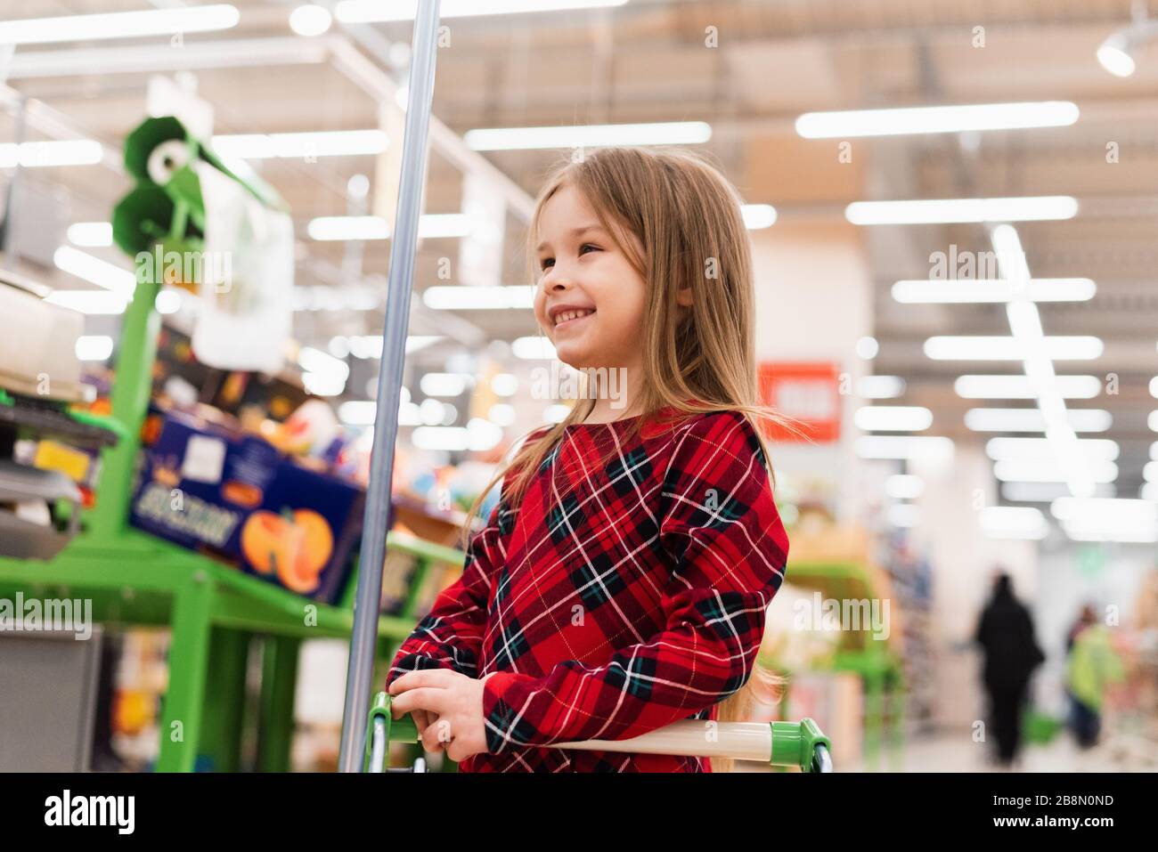 Sales and shopping. Little cute girl with shopping cart standing in ...