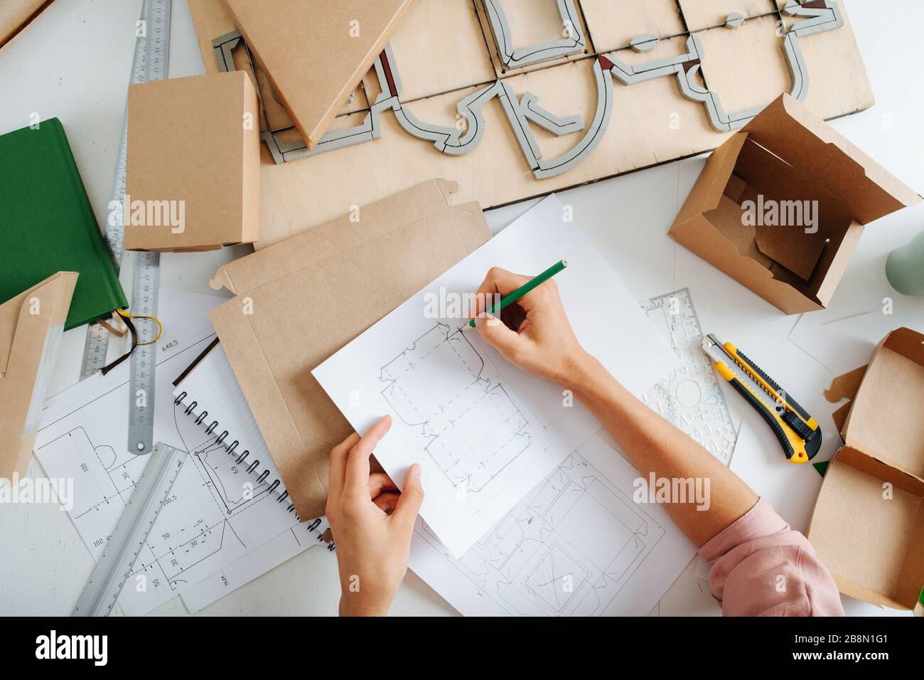 Designer in the works, she makes a drawing of a new box Stock Photo - Alamy