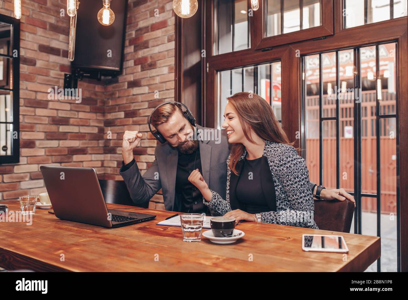 Happy business people celebrate success looking at laptop screen while ...