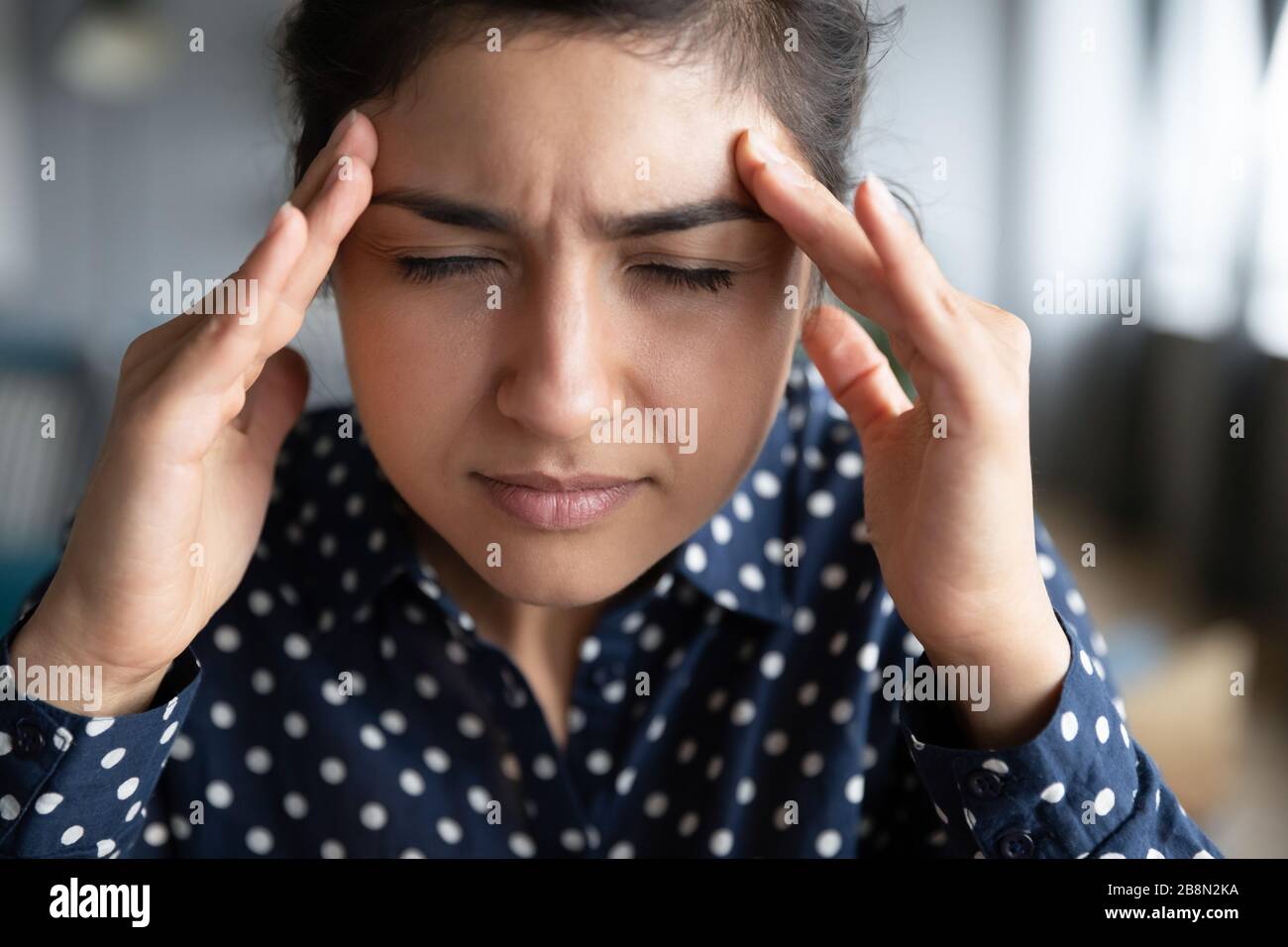Close up exhausted Indian girl touching forehead, suffering from ...