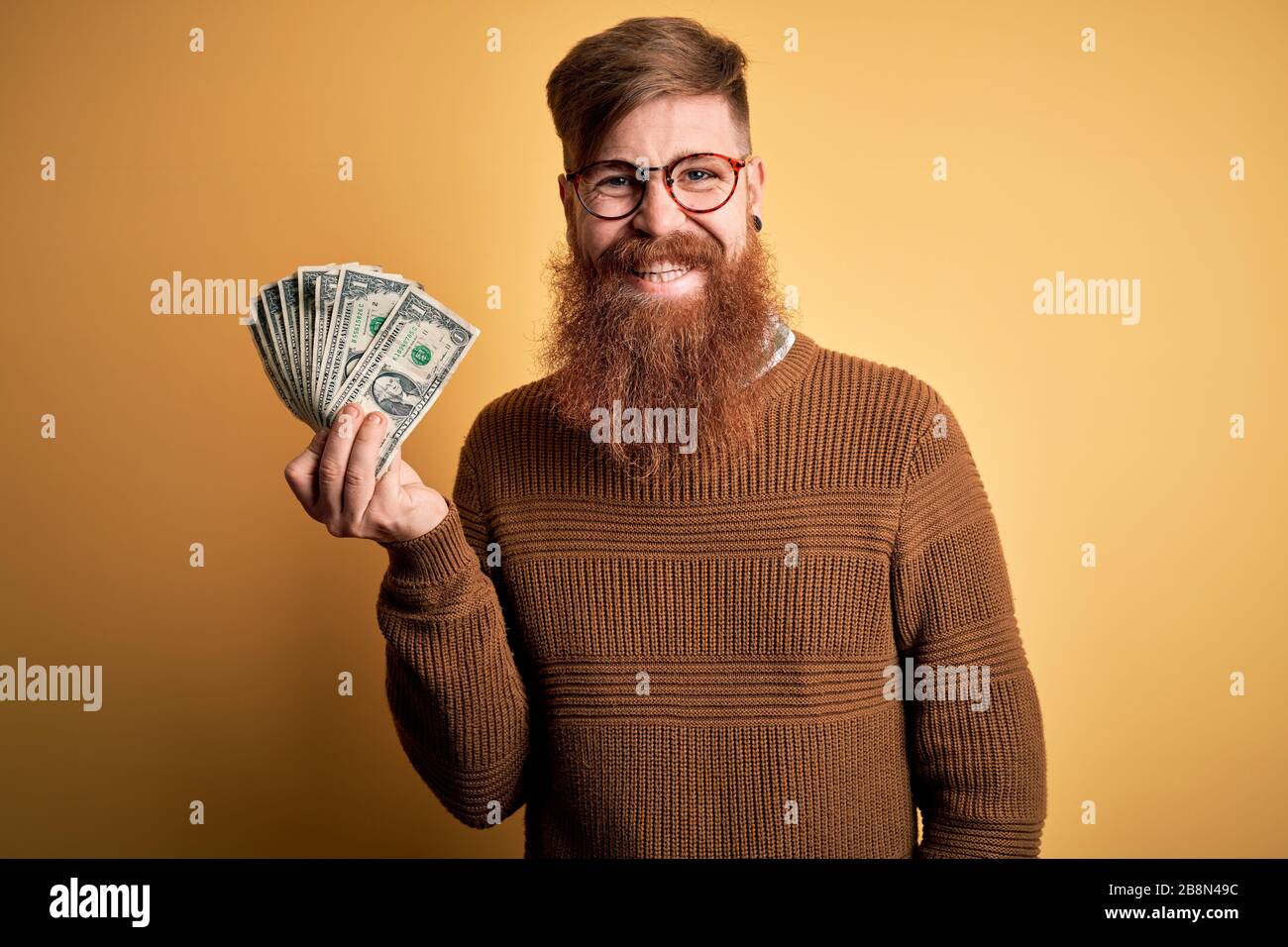 Redhead Irish man with beard holding a bunch of 1 dolla banknotes over ...