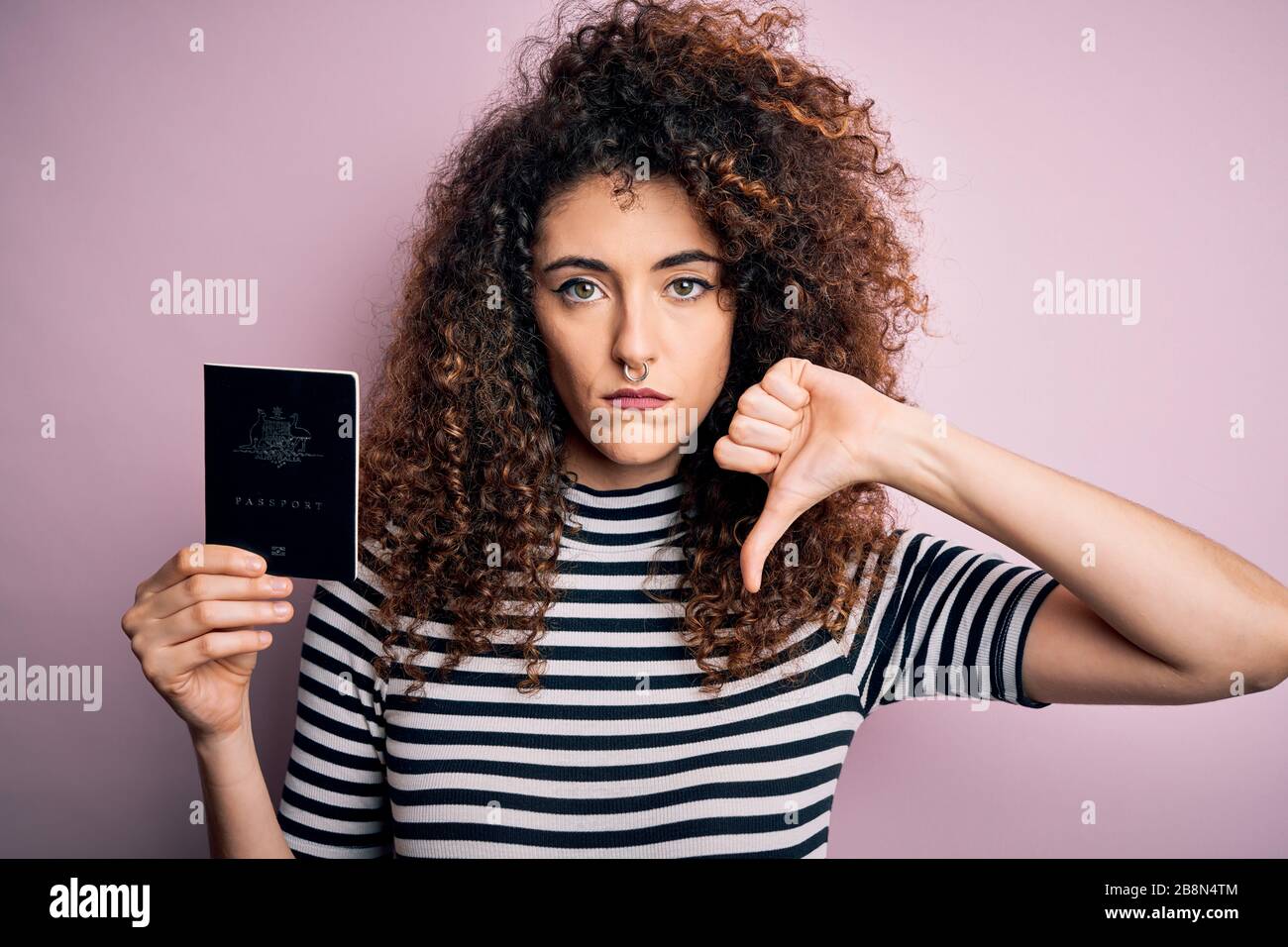 Beautiful tourist woman with curly hair and piercing holding australia ...