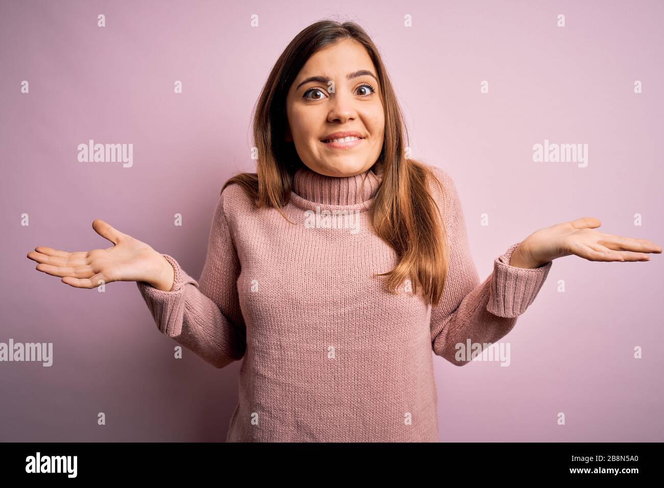 Beautiful young woman wearing turtleneck sweater over pink isolated ...