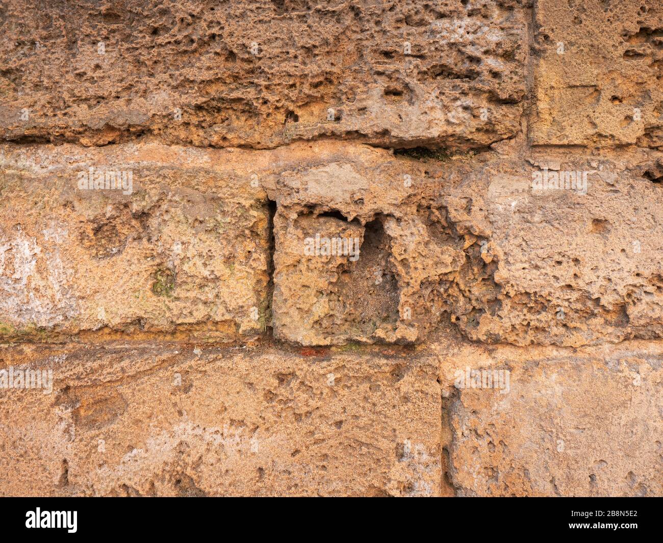 Natural stone wall with stones in several colors such as dark red ...