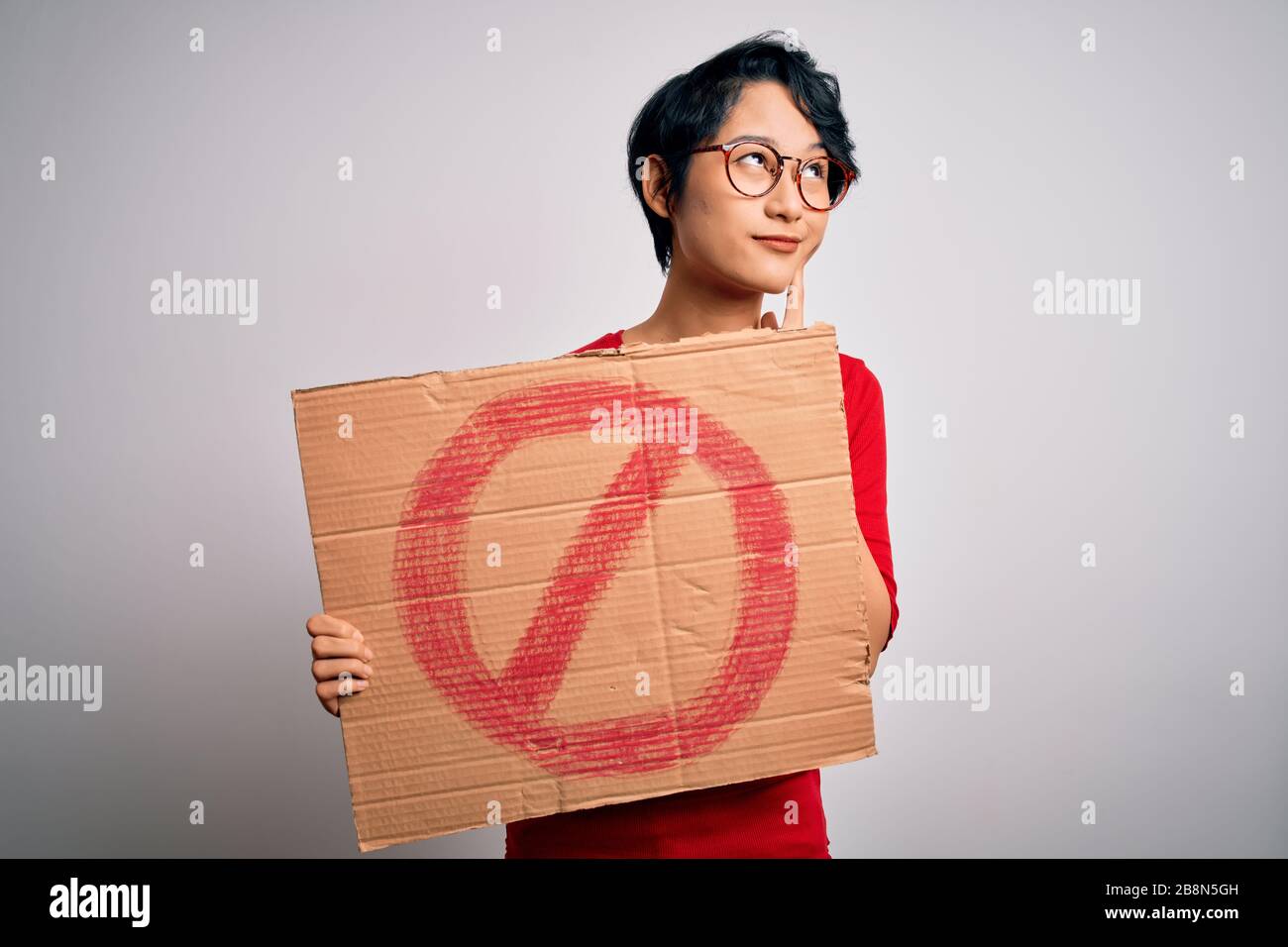 Young beautiful asian girl holding banner with prohibited signal over ...