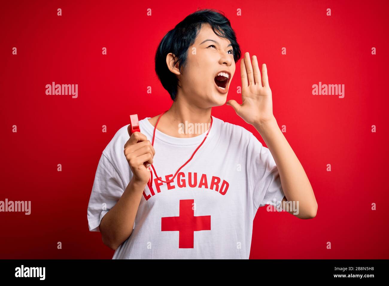 Young beautiful asian lifeguard girl wearing t-shirt with red cross ...