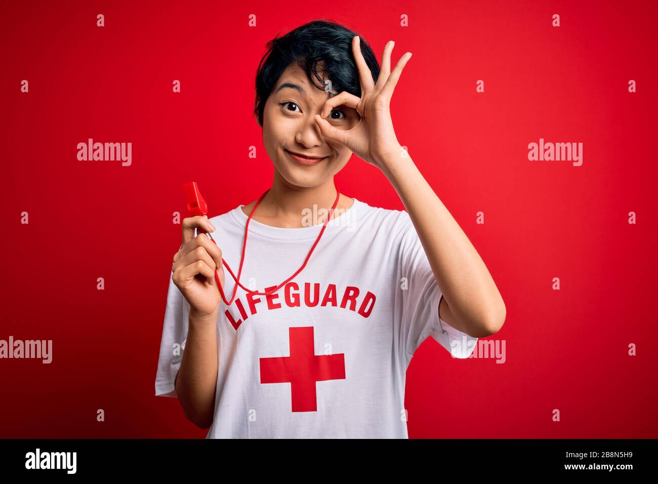 Young beautiful asian lifeguard girl wearing t-shirt with red cross ...